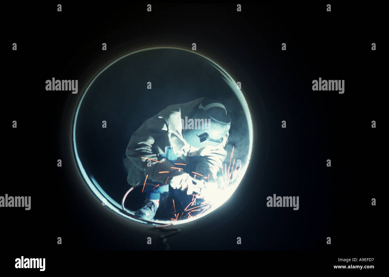 Man welding inside a pipe Stock Photo - Alamy