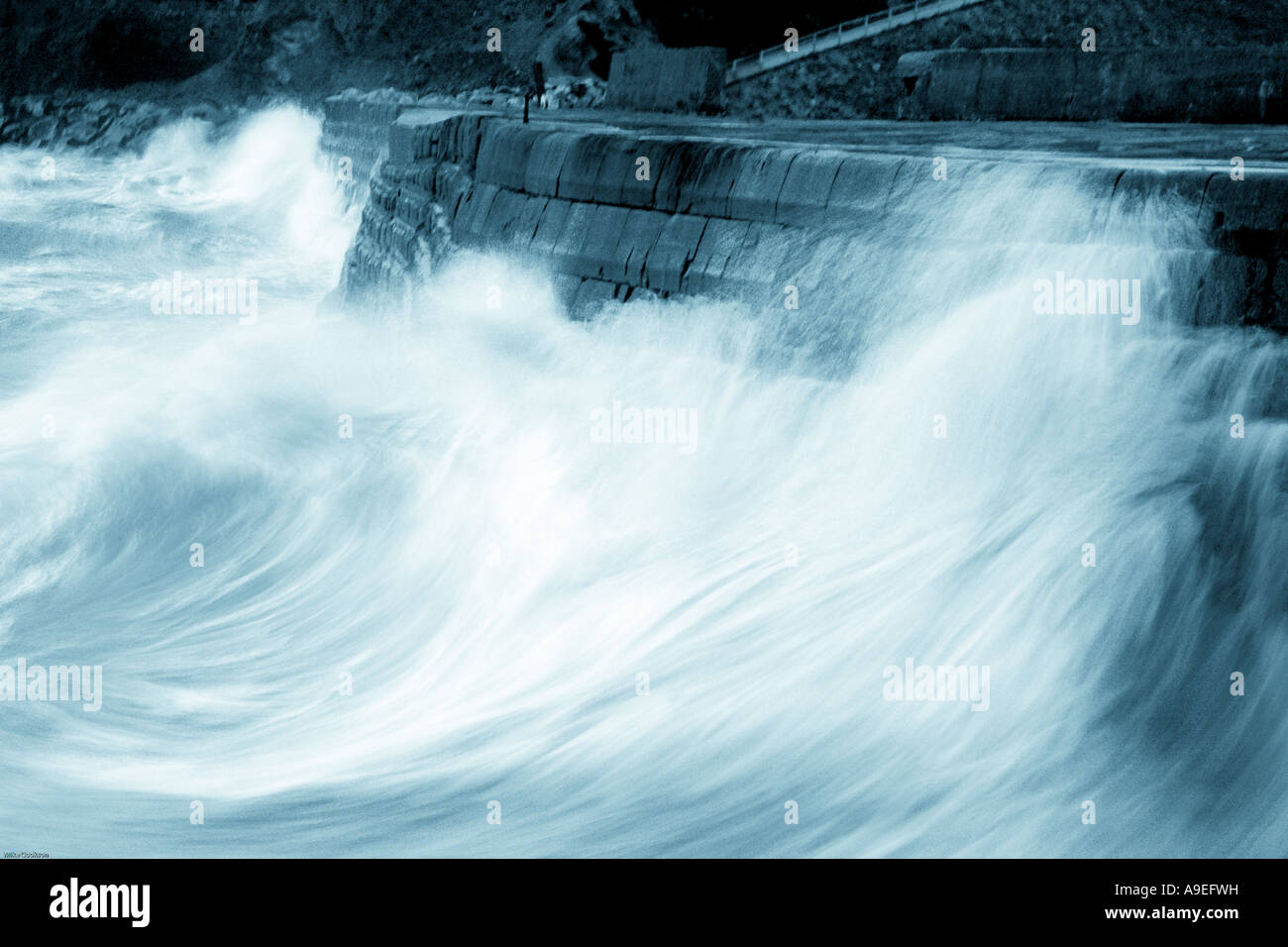Dawn high tide crashes against the sea wall in Whitby, Yorkshire ...