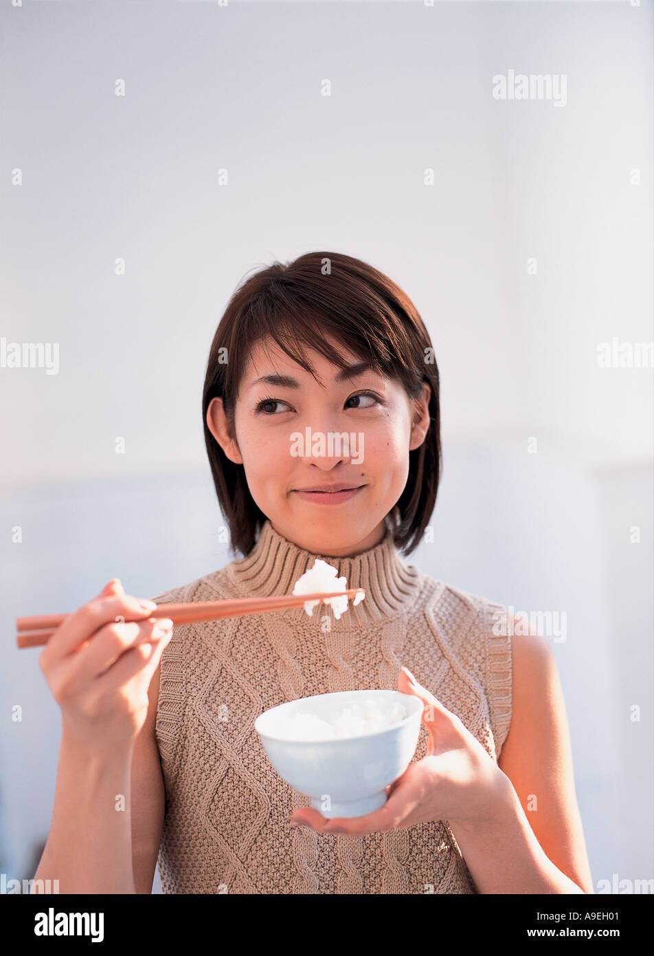 Woman eating rice vertical hi-res stock photography and images - Alamy