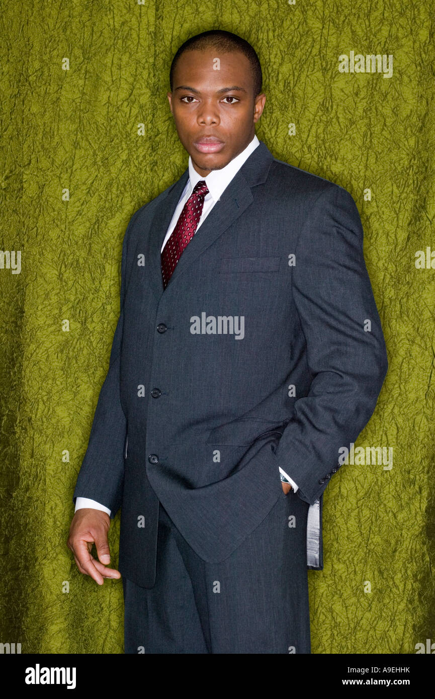 Young black business man wearing a suit and tie in studio green ...