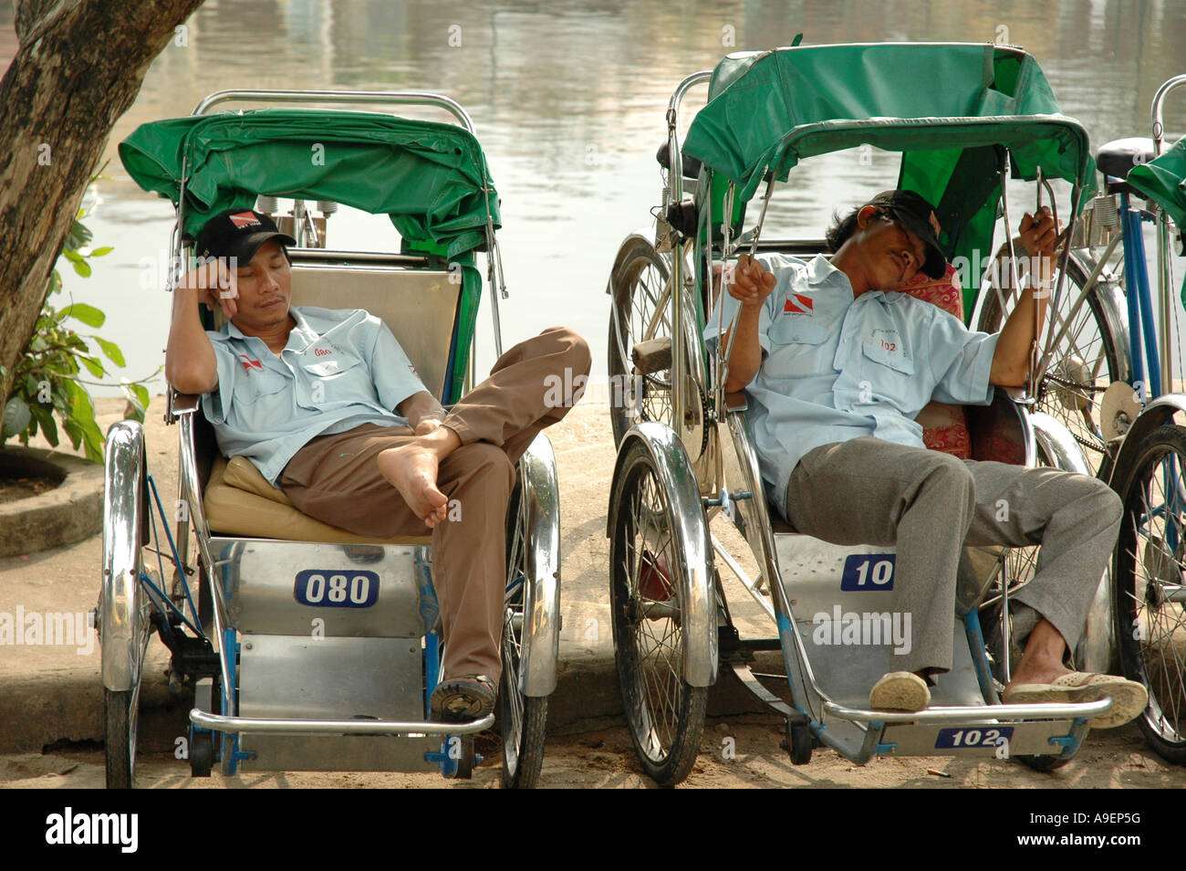 Cyclo drivers take an afternoon nap by the Thu Bon River in Hoi An ...