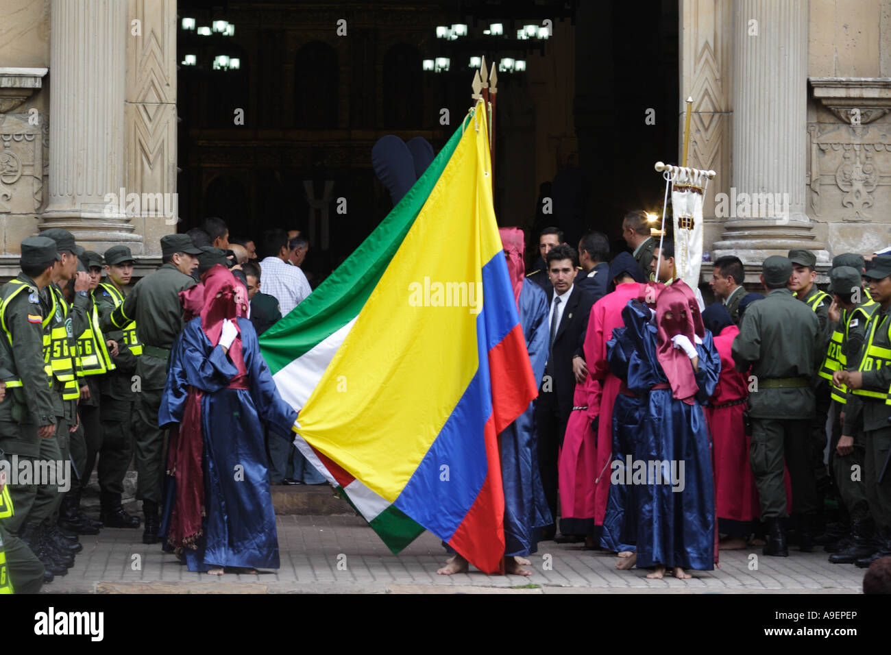 people in penitence costume with flags in a catholic procession in ...