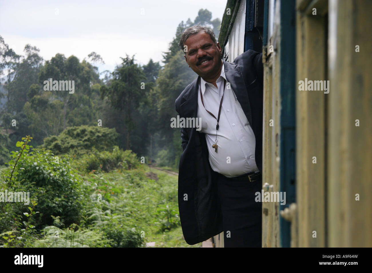 Train conductor on the British Raj built, Nilgiri Mountain Railway, the ...