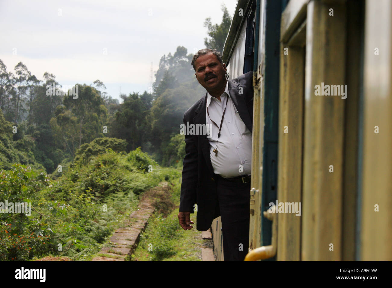 Train conductor on the British Raj built, Nilgiri Mountain Railway, the ...