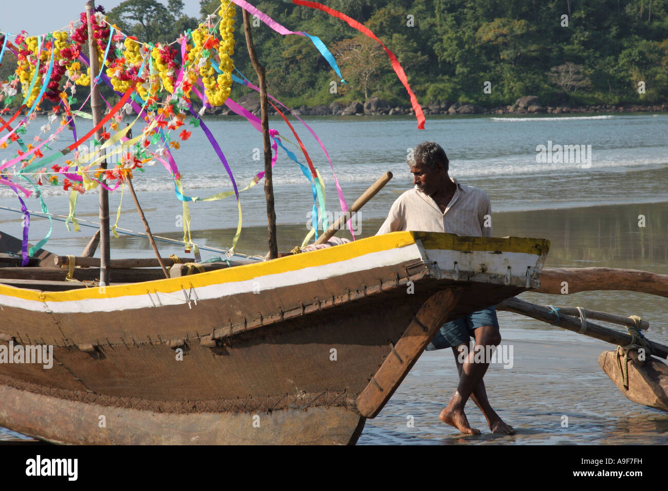 A local fisherman pushes his decorated boat out to sea for a special ...