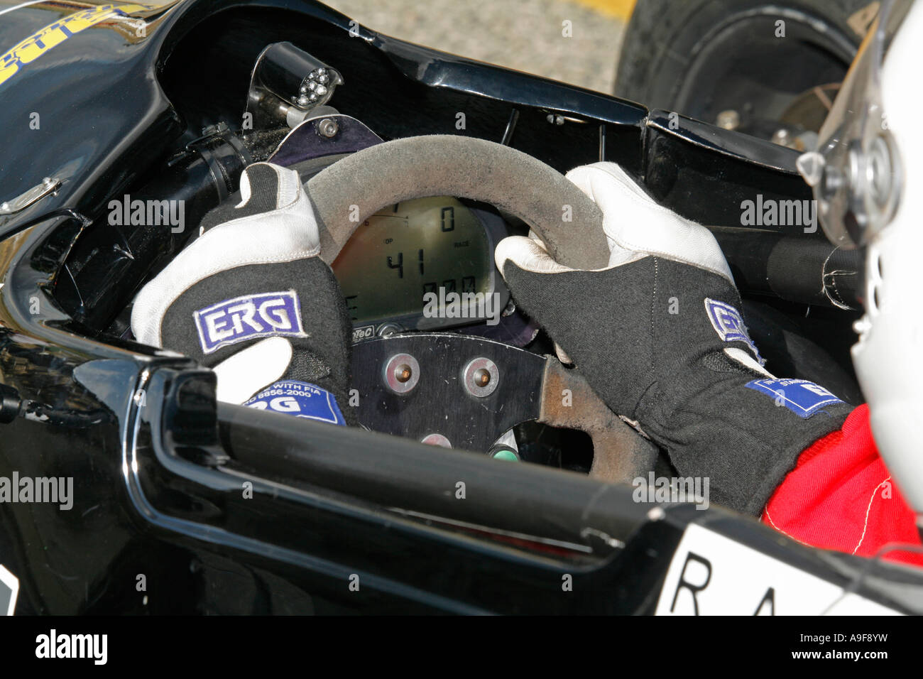 gloved hands of an open wheeler race car driver gripping steering wheel ...