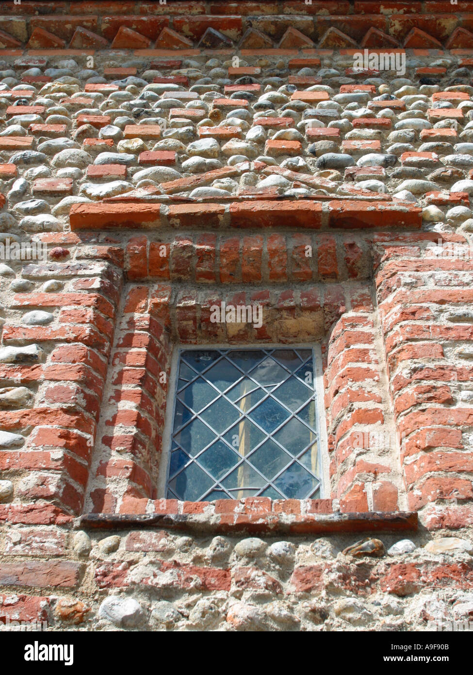 Old lead paned window in preserved traditional flint and brick wall ...