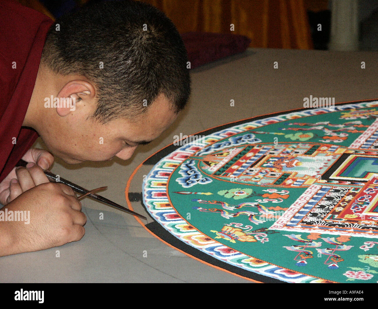 Buddhist Monk working on a sand painting peace mandala created at the V ...