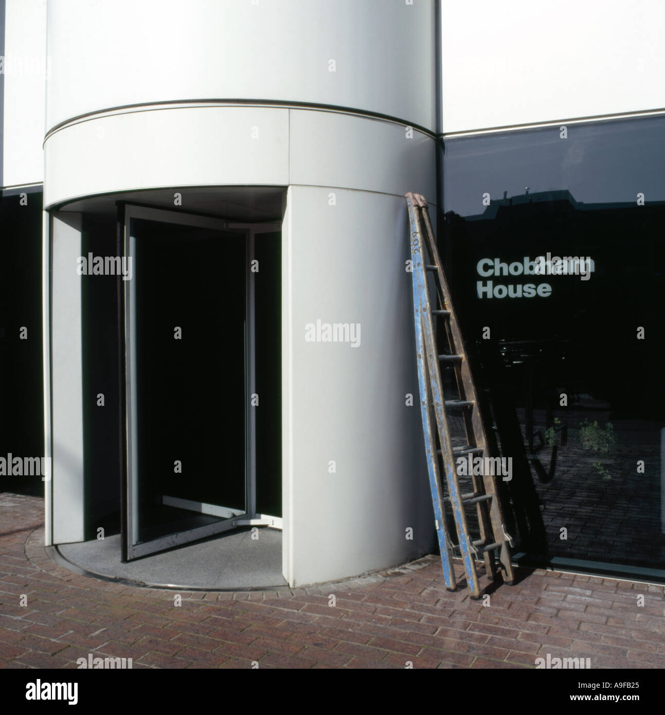 Tatty window cleaner ladder in front of the entrance to a smart modern ...