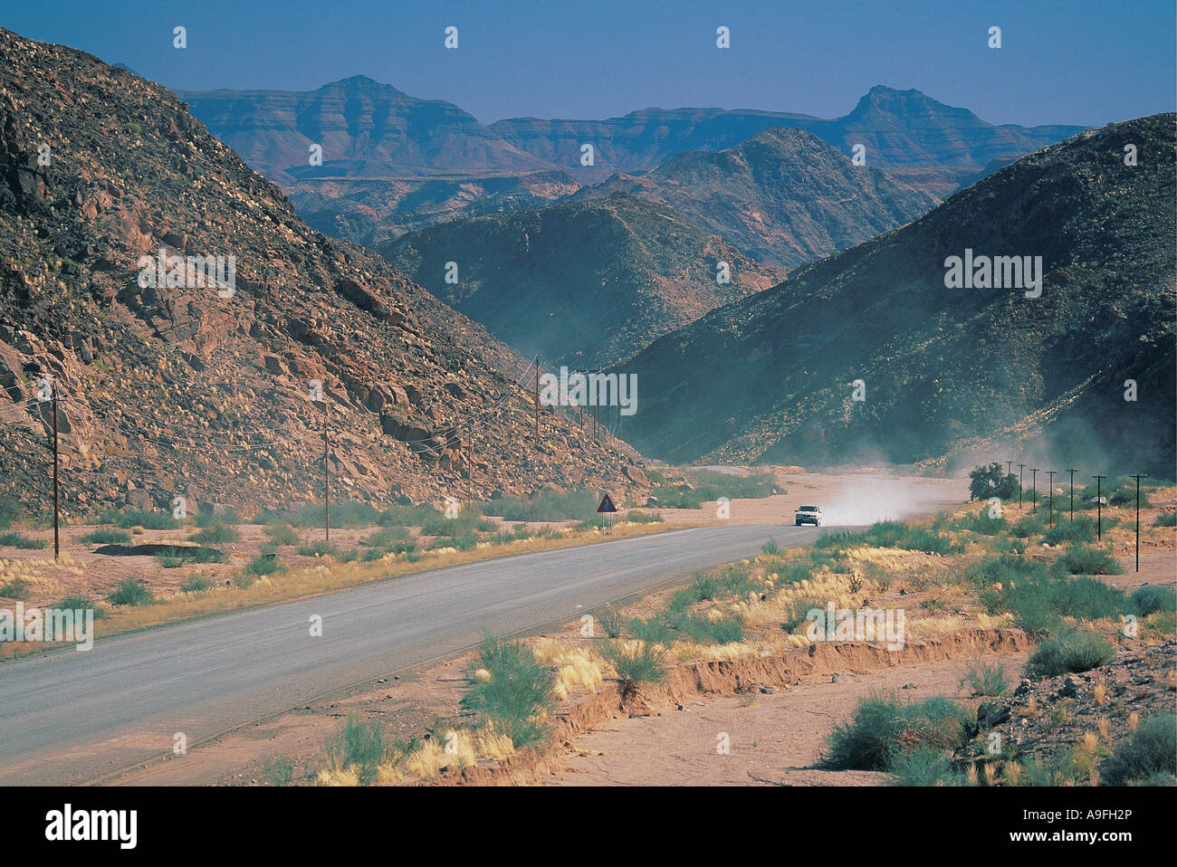 Car raising dust on the road from Fish River Canyon Park Namibia south ...