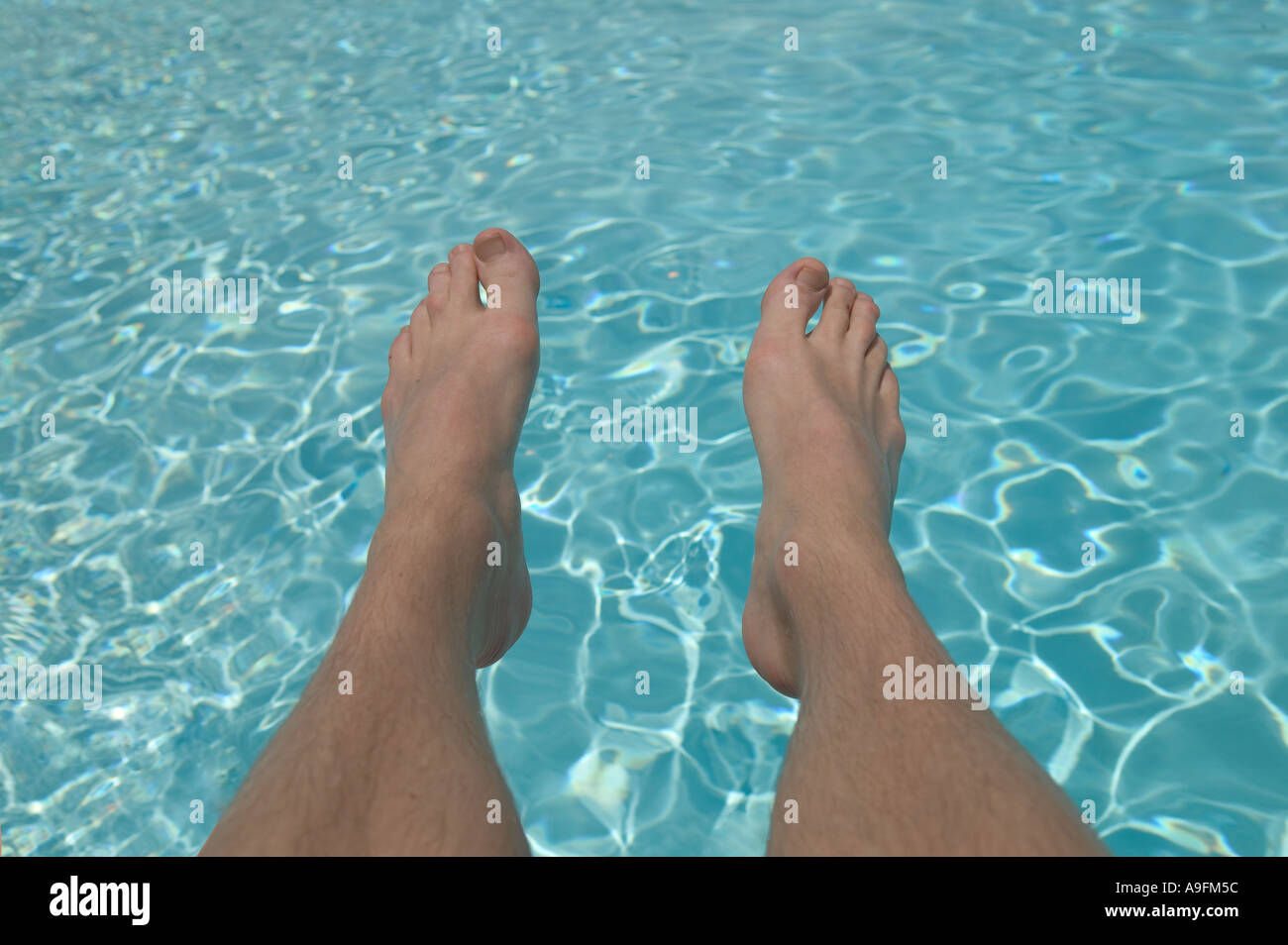 Pair of feet in swimming pool Stock Photo - Alamy