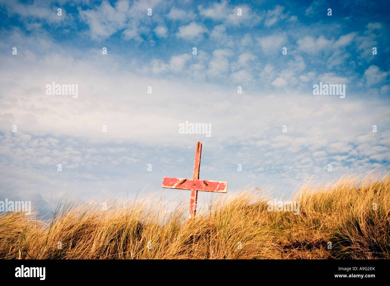 Cross and missing lifering amongst the grass and sand dunes of the ...
