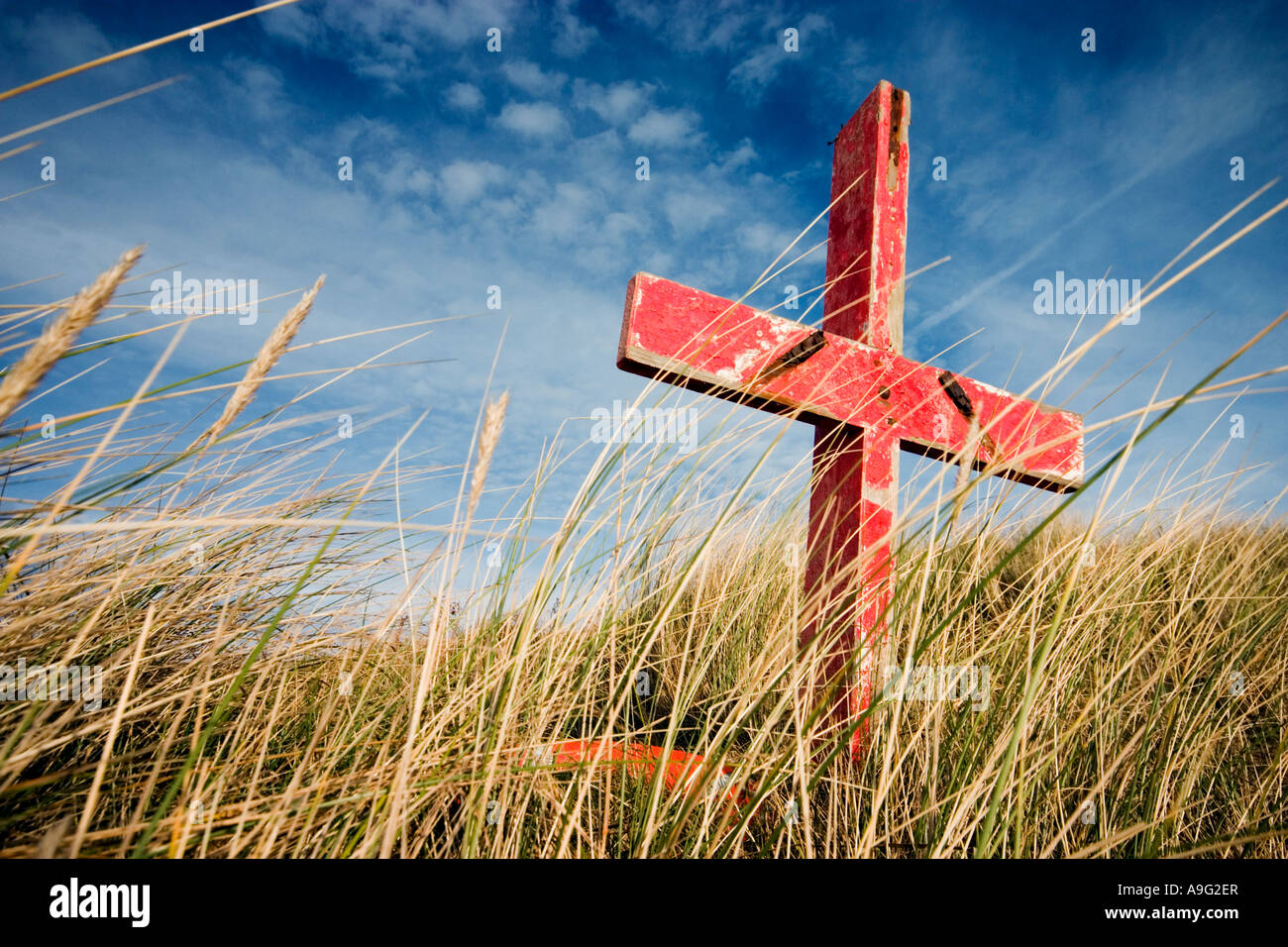 Cross and missing lifering amongst the grass and sand dunes of the ...