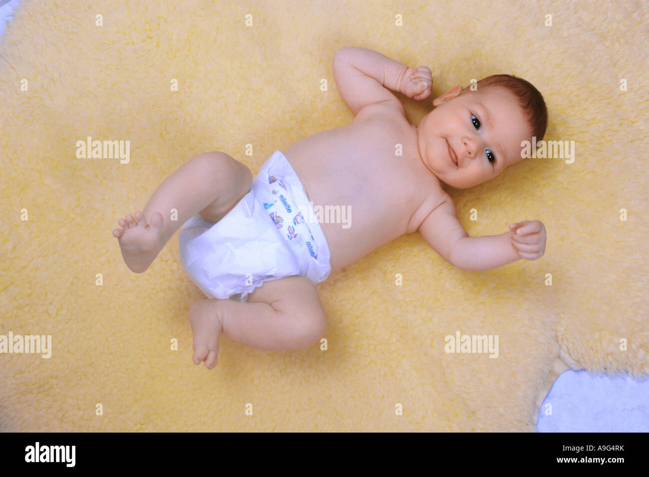 baby lying on a sheepskin rug Stock Photo - Alamy