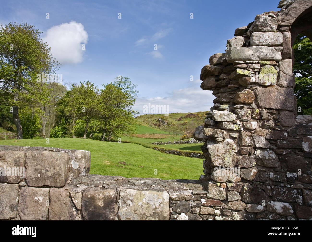 Derelict medieval chapel wall ruin with countryside and blue sky in ...