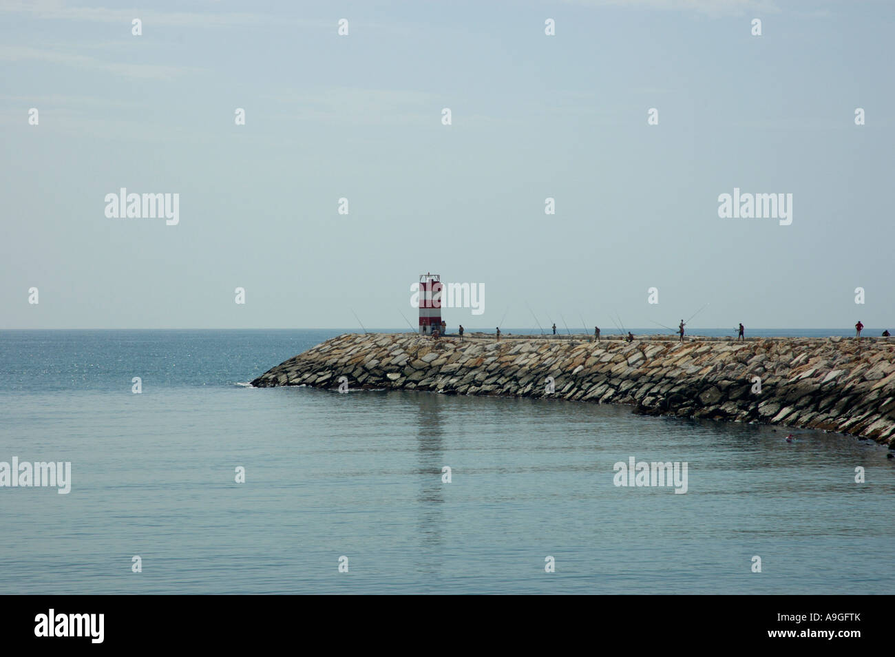 Harbour wall jetting out into the sea Stock Photo - Alamy