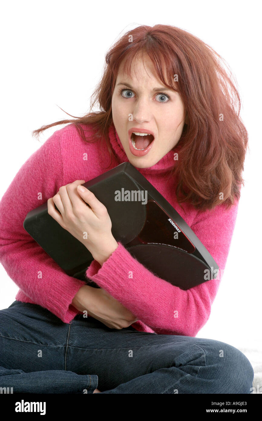 Young woman holding weighing scales hi-res stock photography and images ...
