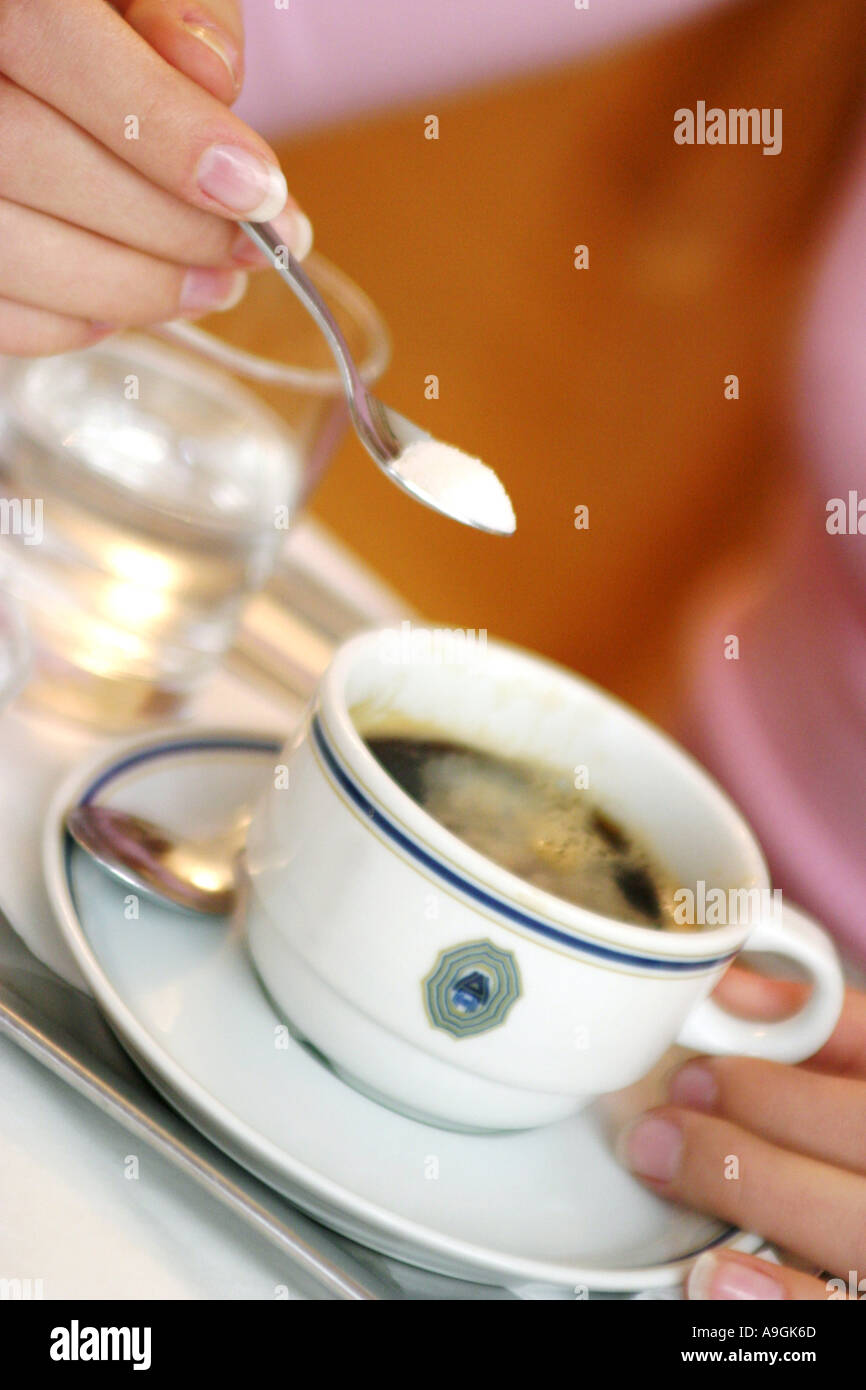 female hand strewing sugar into a cup of coffee Stock Photo - Alamy