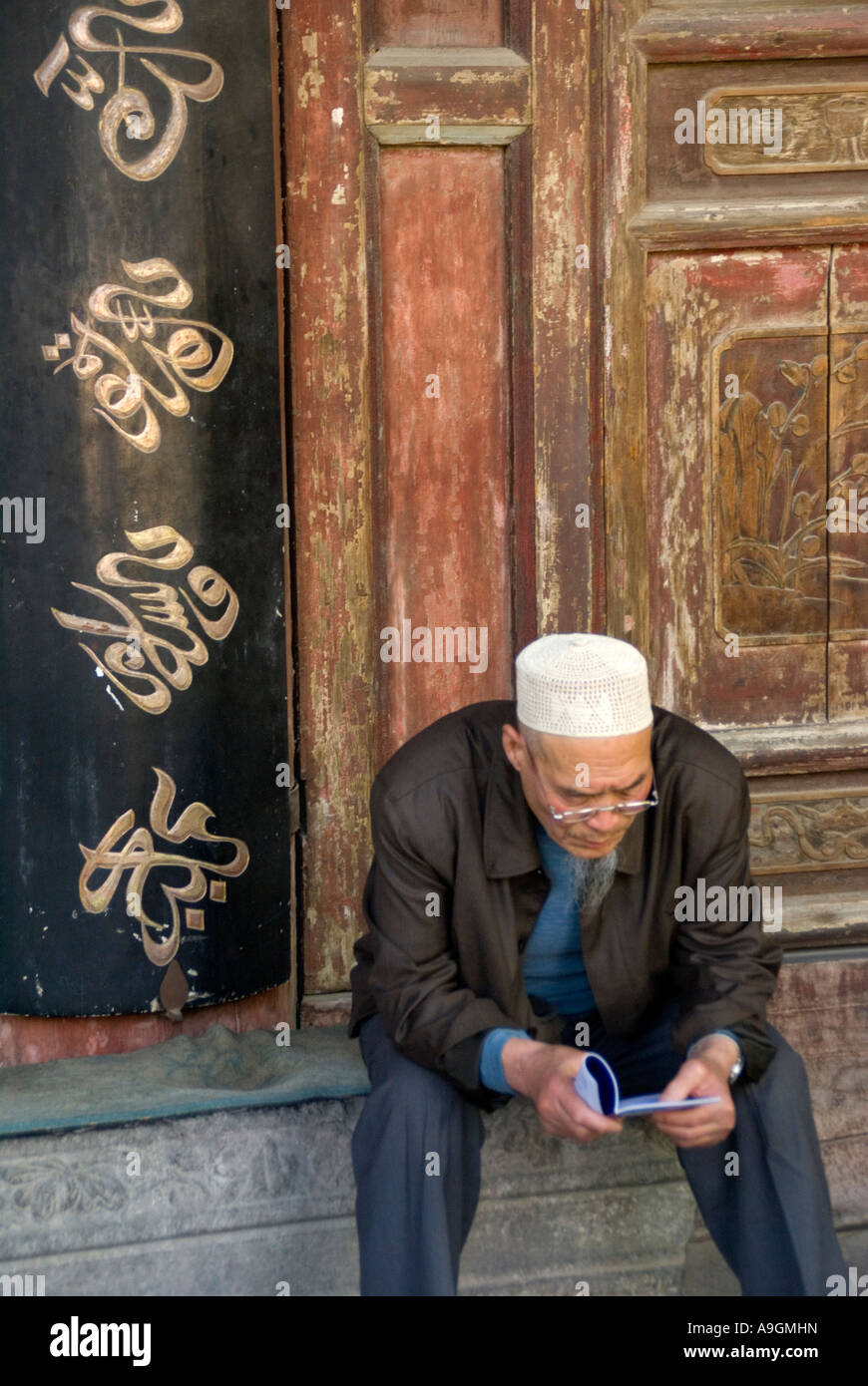 Xi'an's Great Mosque with Hui Muslim man sitting at entrance to prayer ...