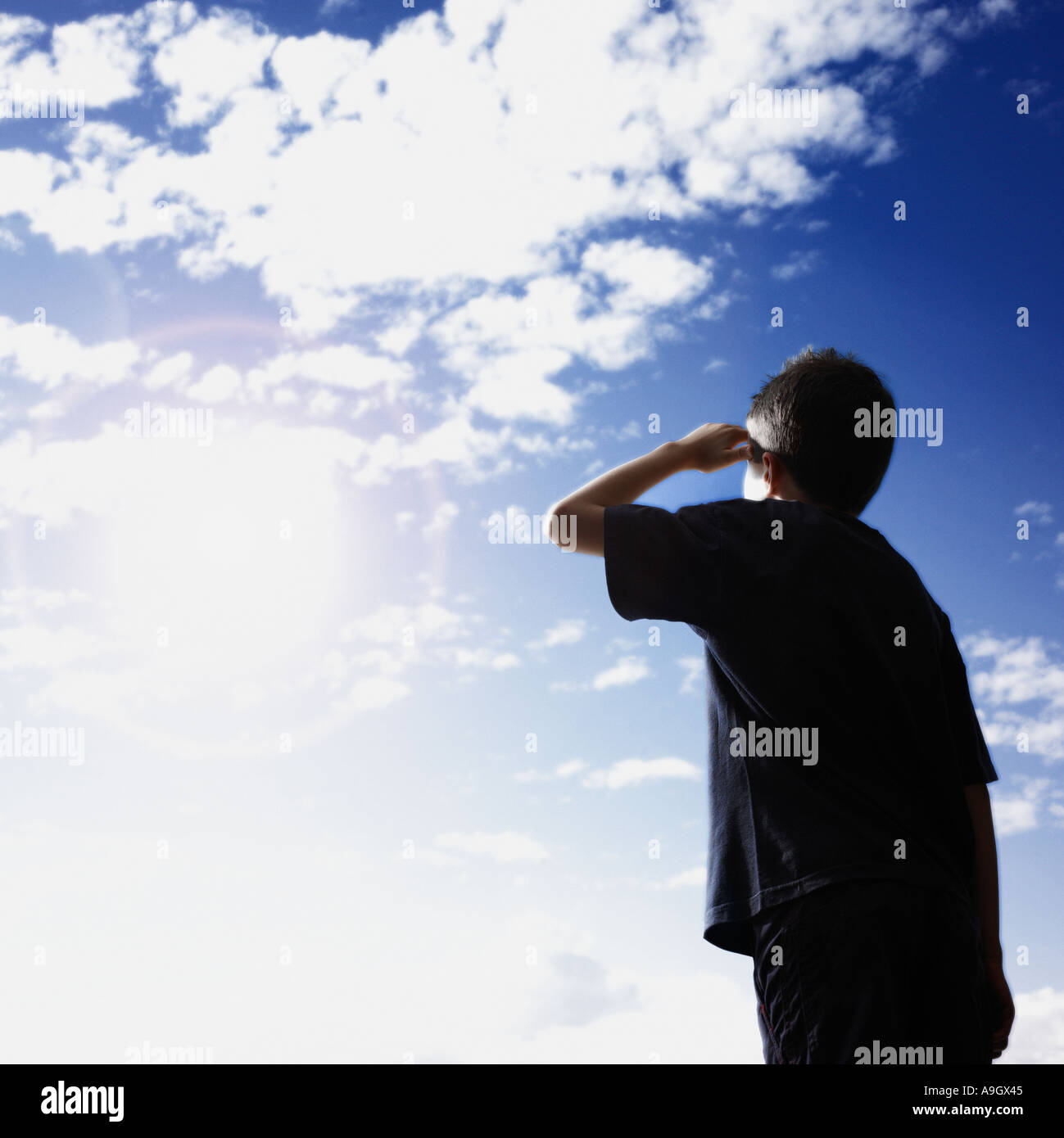 Boy standing looking at sky Stock Photo - Alamy