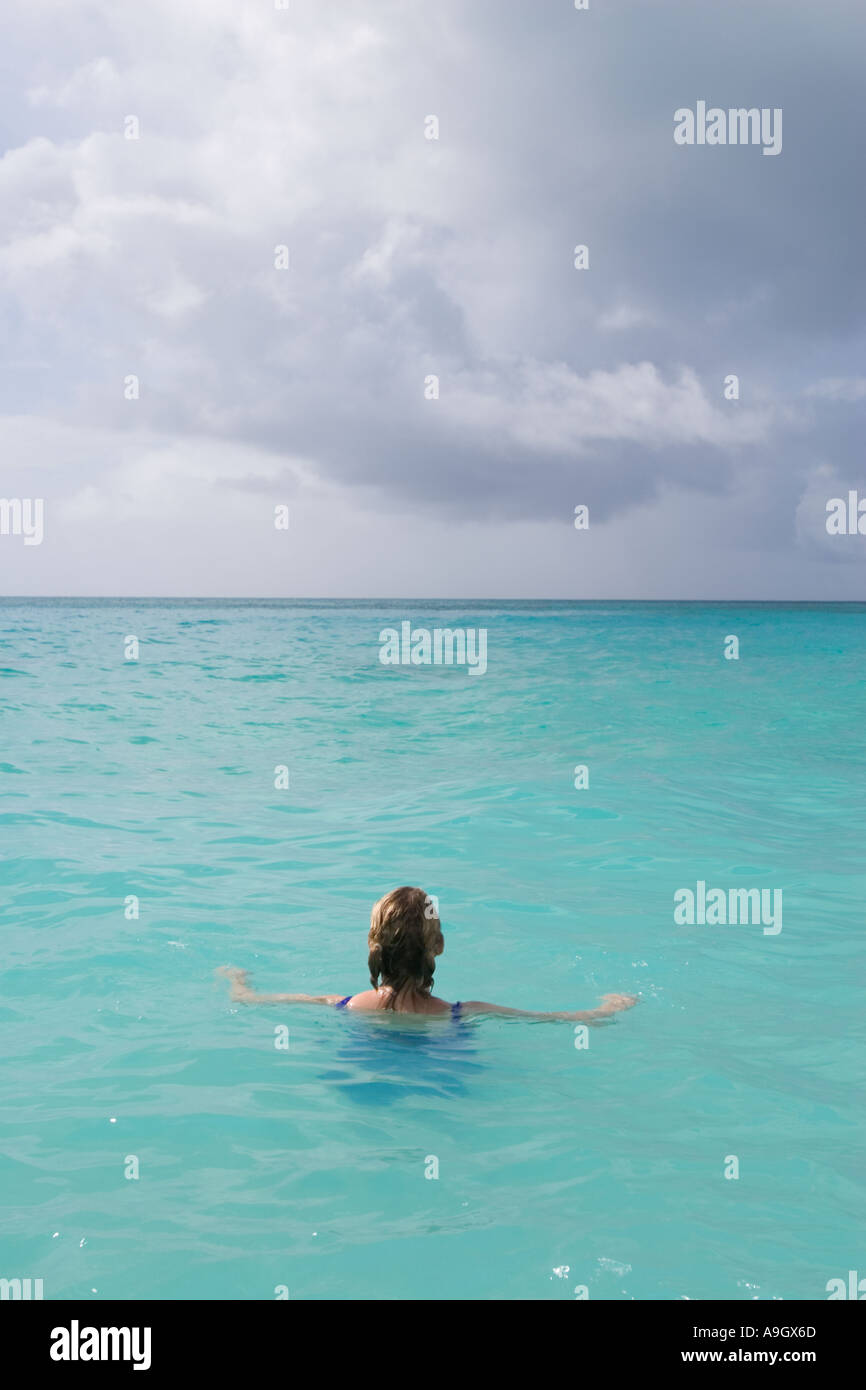 Woman swimming in Caribbean watching storm clouds Stock Photo - Alamy