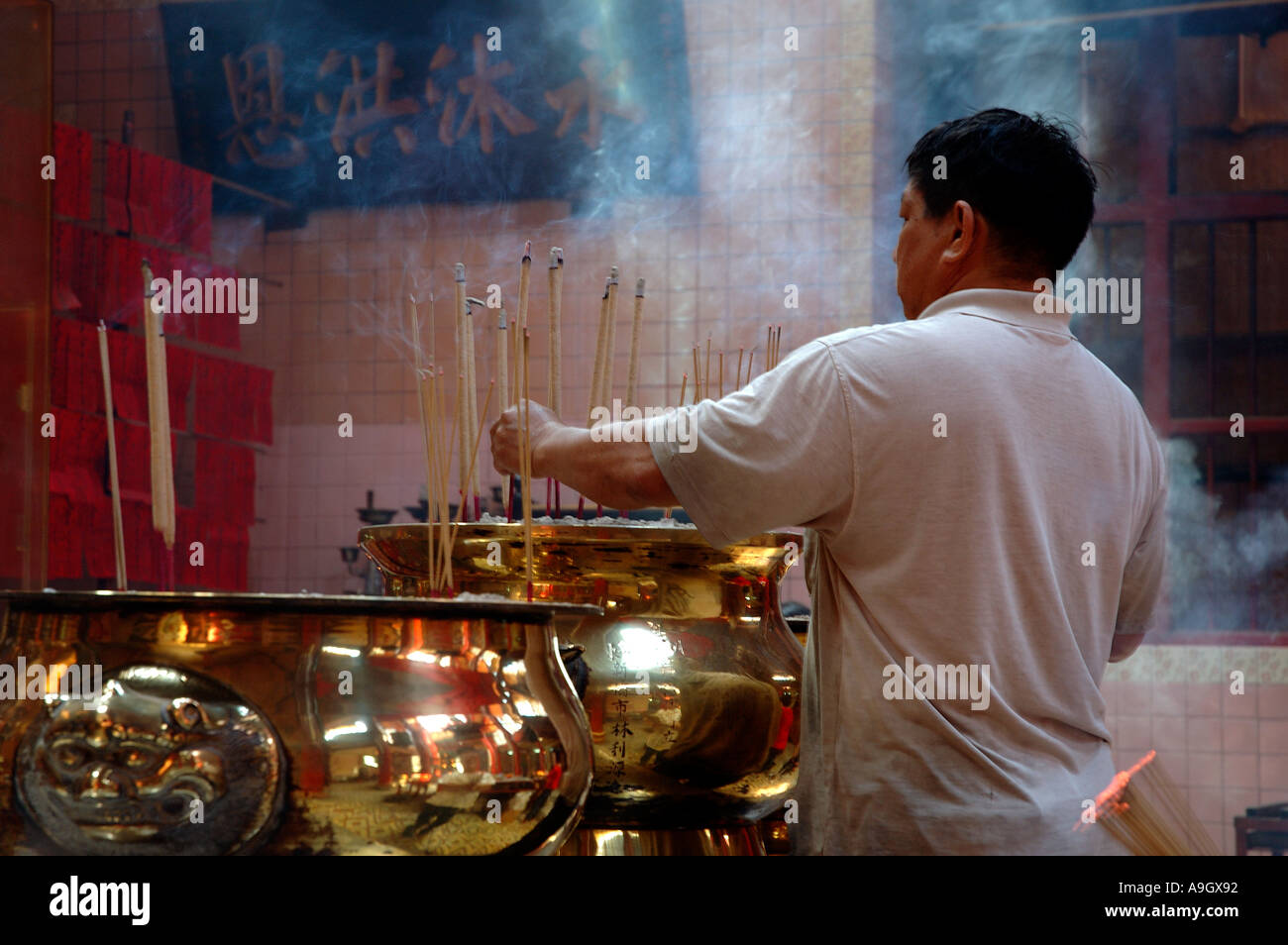 Chinese man praying at temple Stock Photo - Alamy