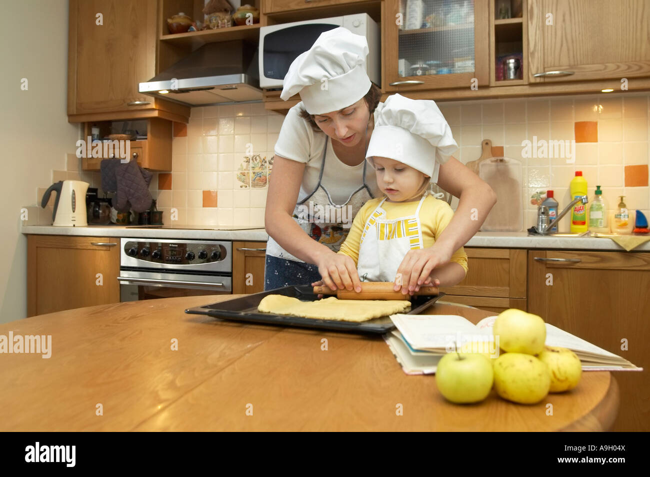 Little girl helps her mother at a kitchen Stock Photo - Alamy