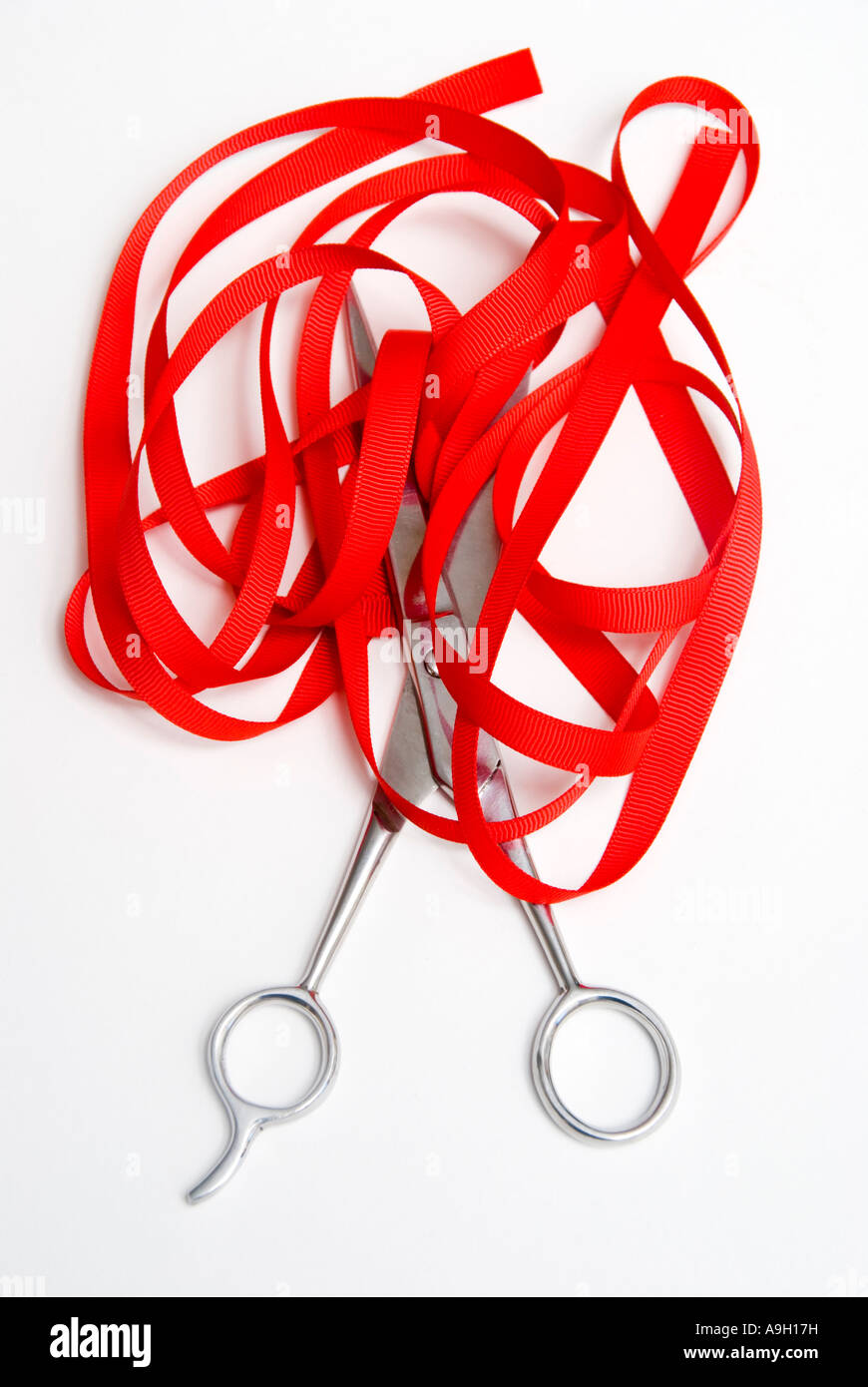 Cutting red tape with scissors Stock Photo - Alamy