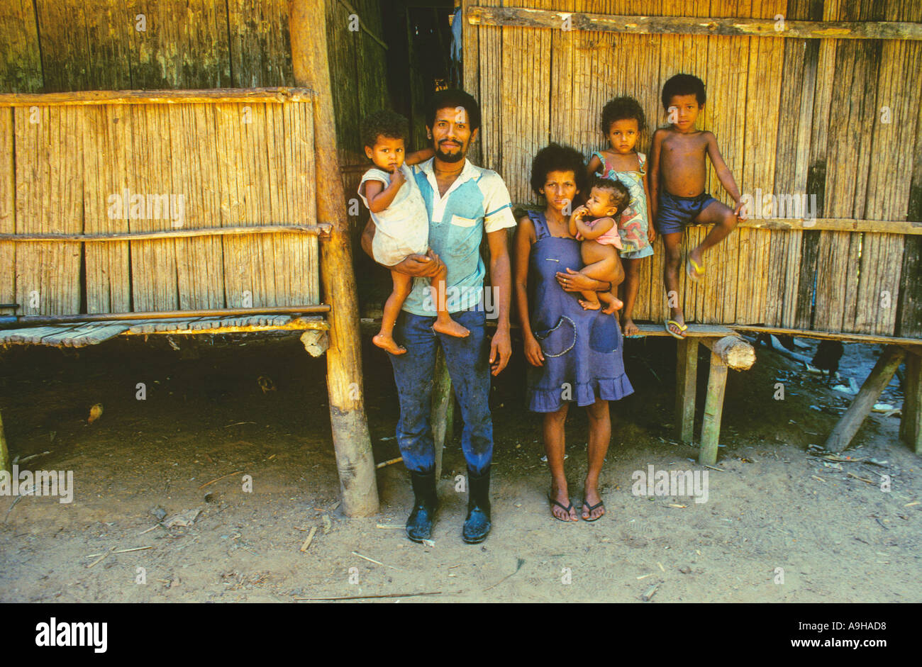 A poor rubber tapper family infront of house in the Amazon rainforest ...