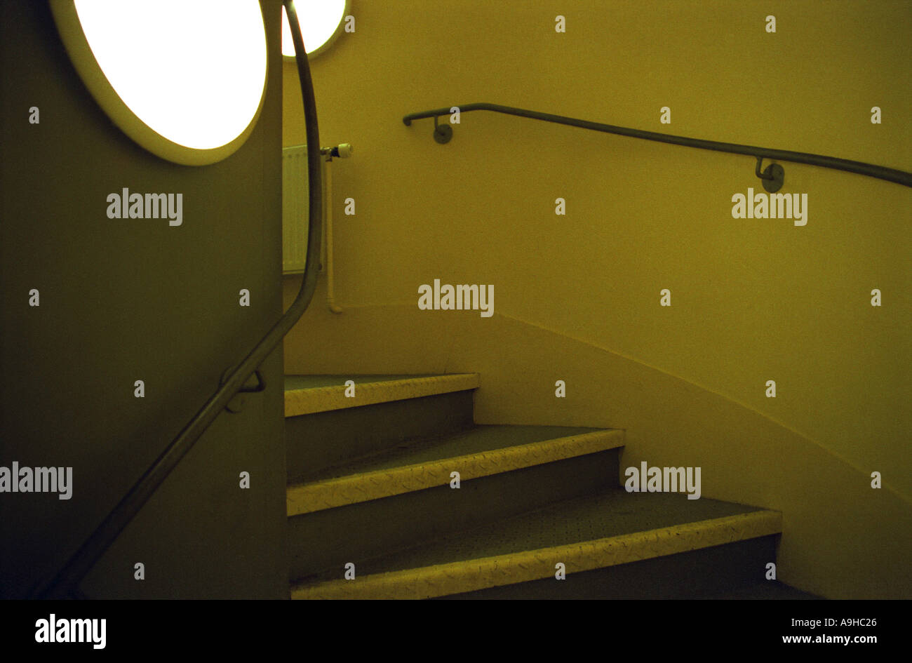 Dinly lit yellow spiral staircase Stock Photo - Alamy