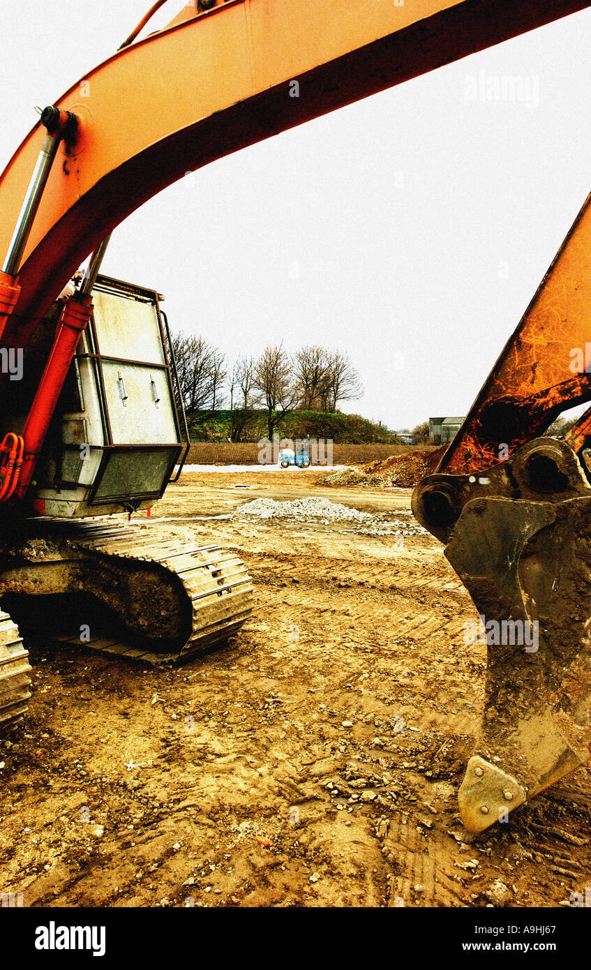 Orange Excavator breaking ground on a new building site in the UK Stock ...