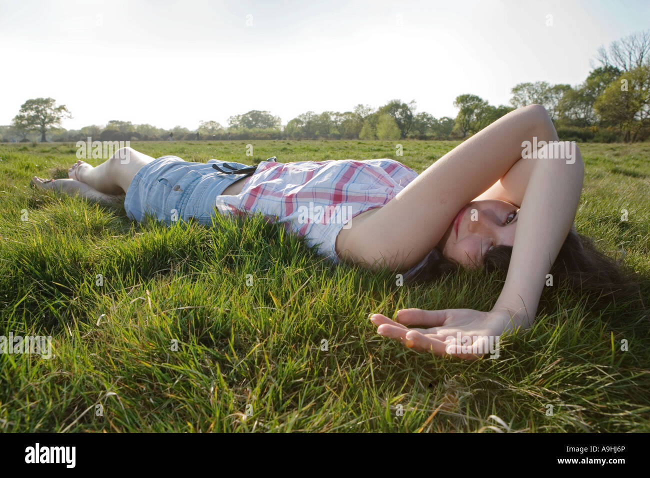 Girl Lying Down In A Park Stock Photo Alamy