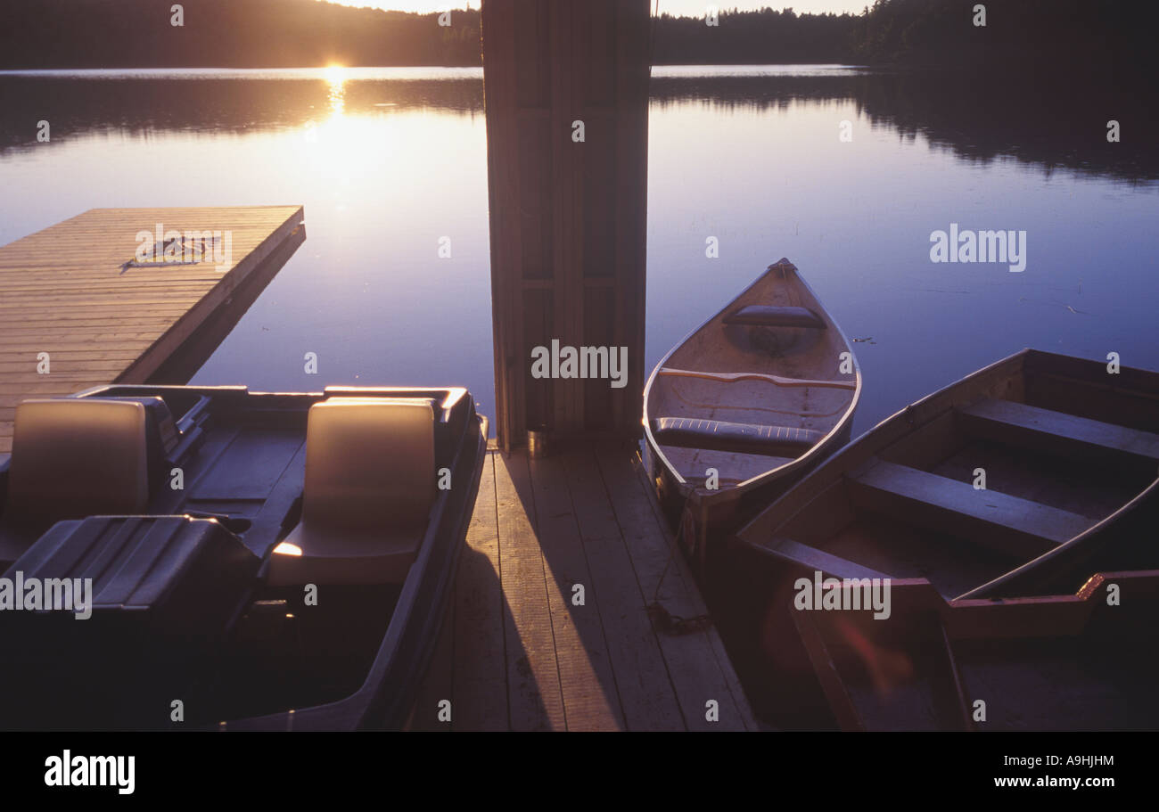 View from boathouse as late summer sun sets over the lake, boats ...