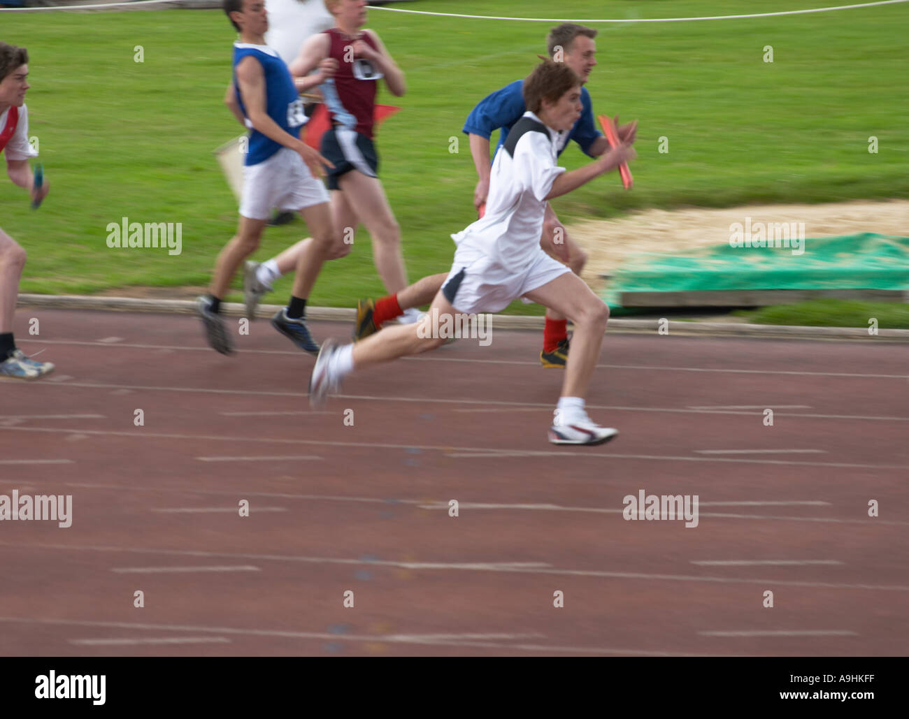 Young male athletes in relay race Stock Photo - Alamy