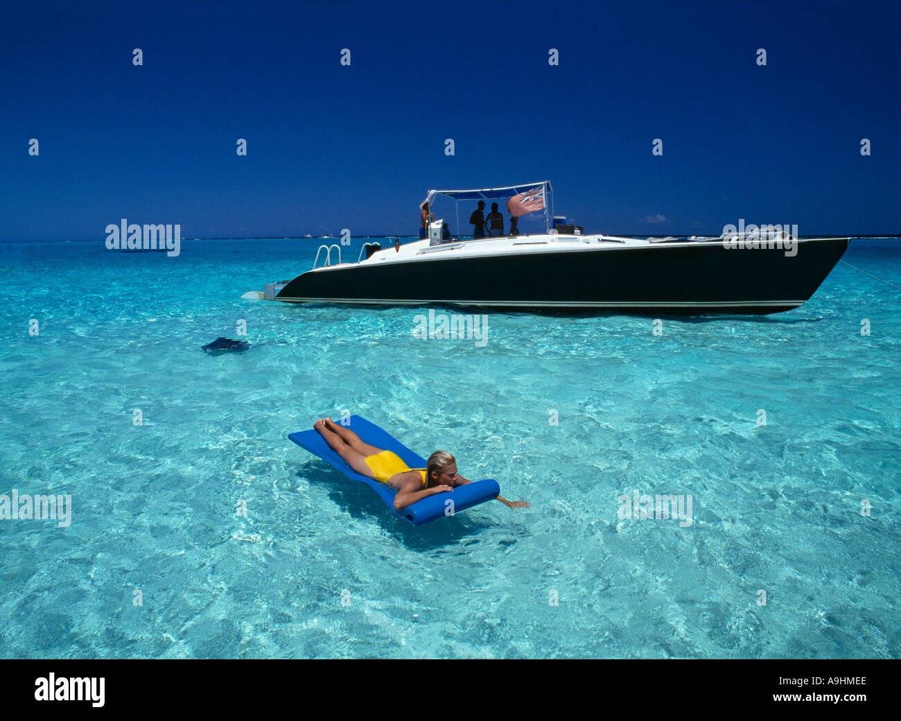 Grand Cayman Sandbar Marja on float in yellow suit backside boat behind ...