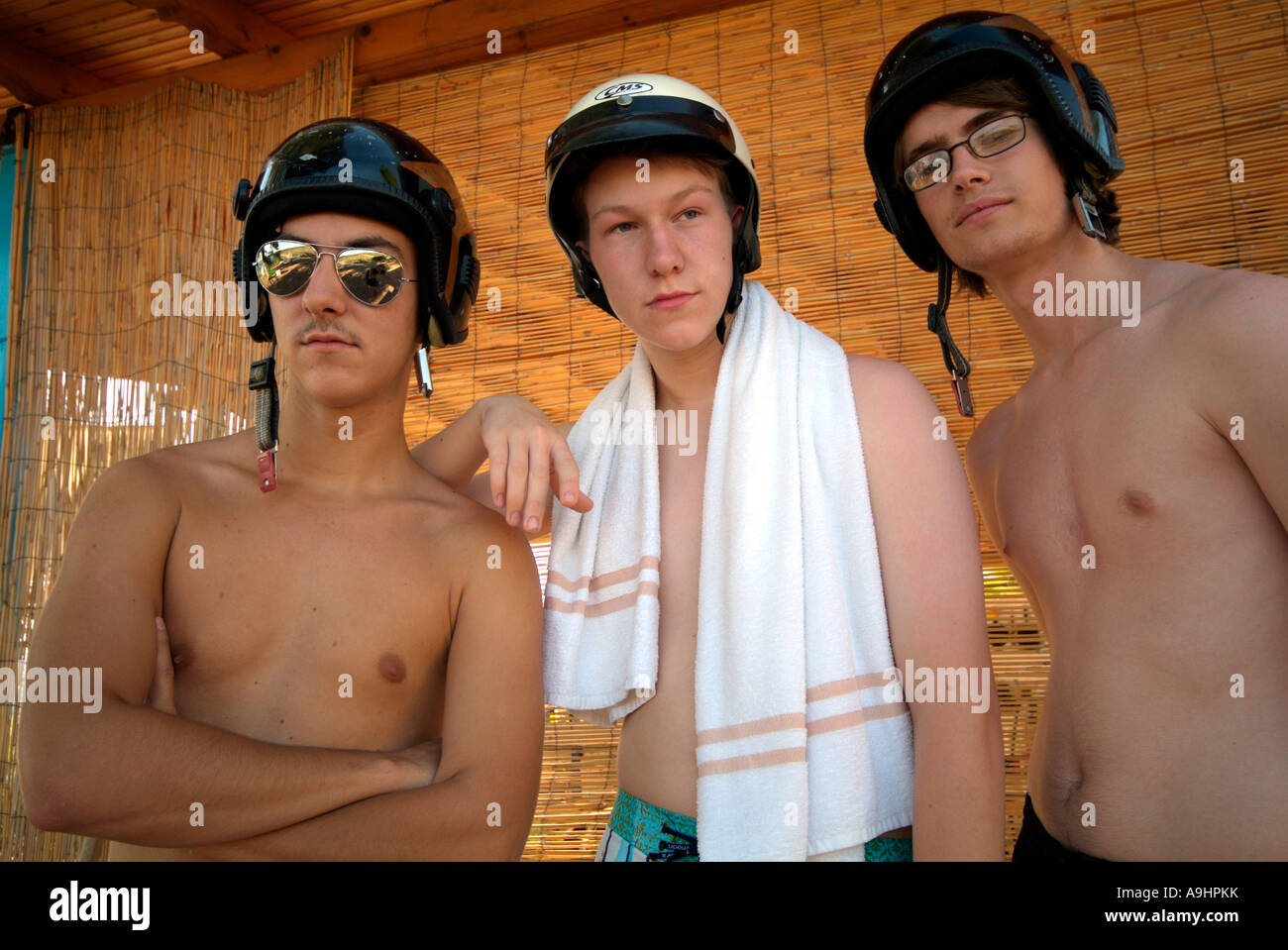 Three young men posing with their retro bike helmets on Thassos Greece ...