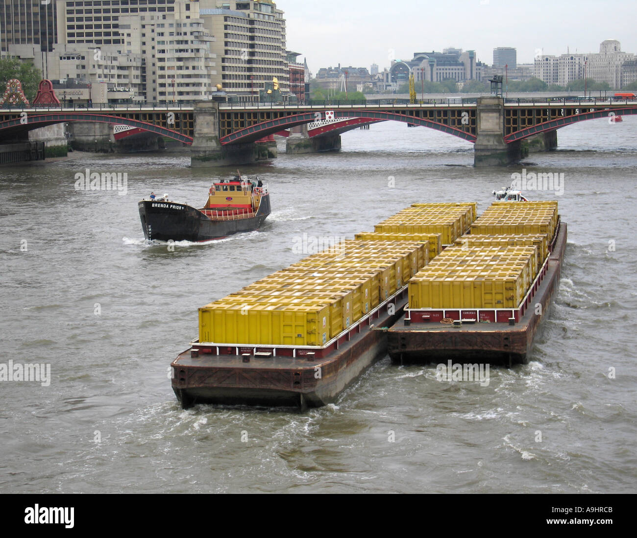 Tug Pulling Barge of Yellow Containers and Small Coaster on River ...