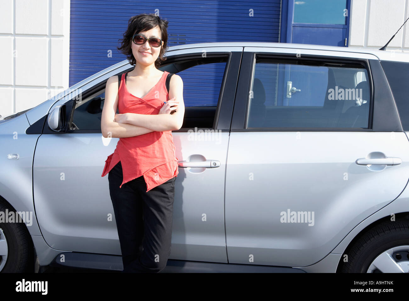 Portrait of Asian woman leaning against car Stock Photo - Alamy