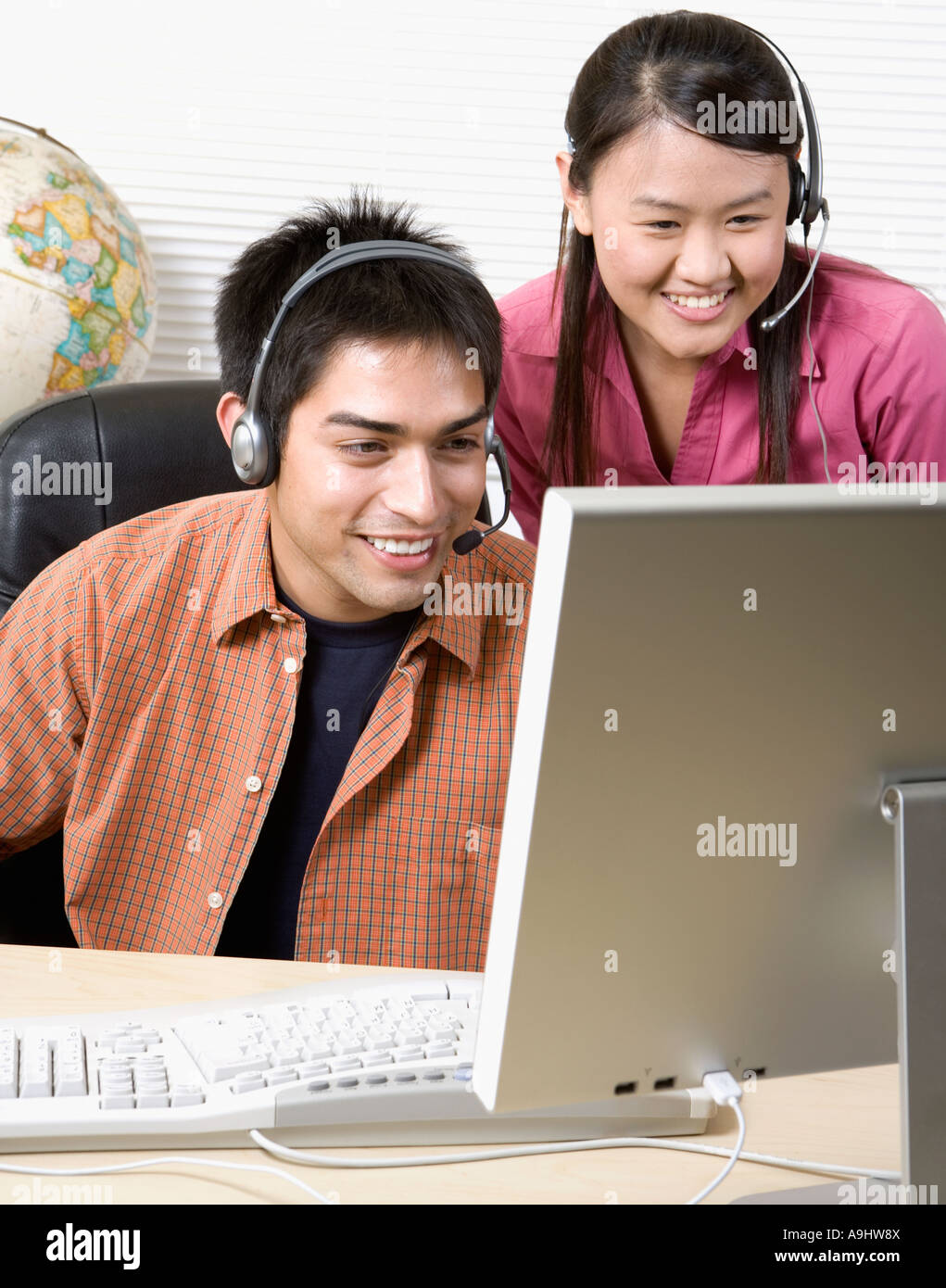 Two young businesspeople looking at computer Stock Photo - Alamy