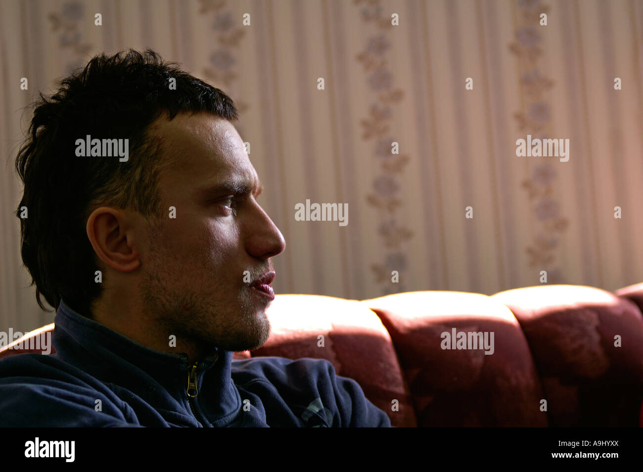 worried man sitting on the couch Stock Photo - Alamy
