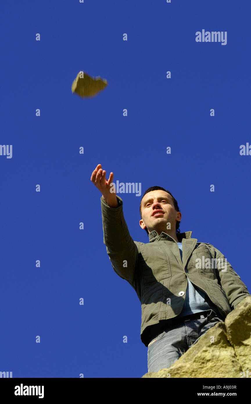 man throwing stone into abyss Stock Photo - Alamy