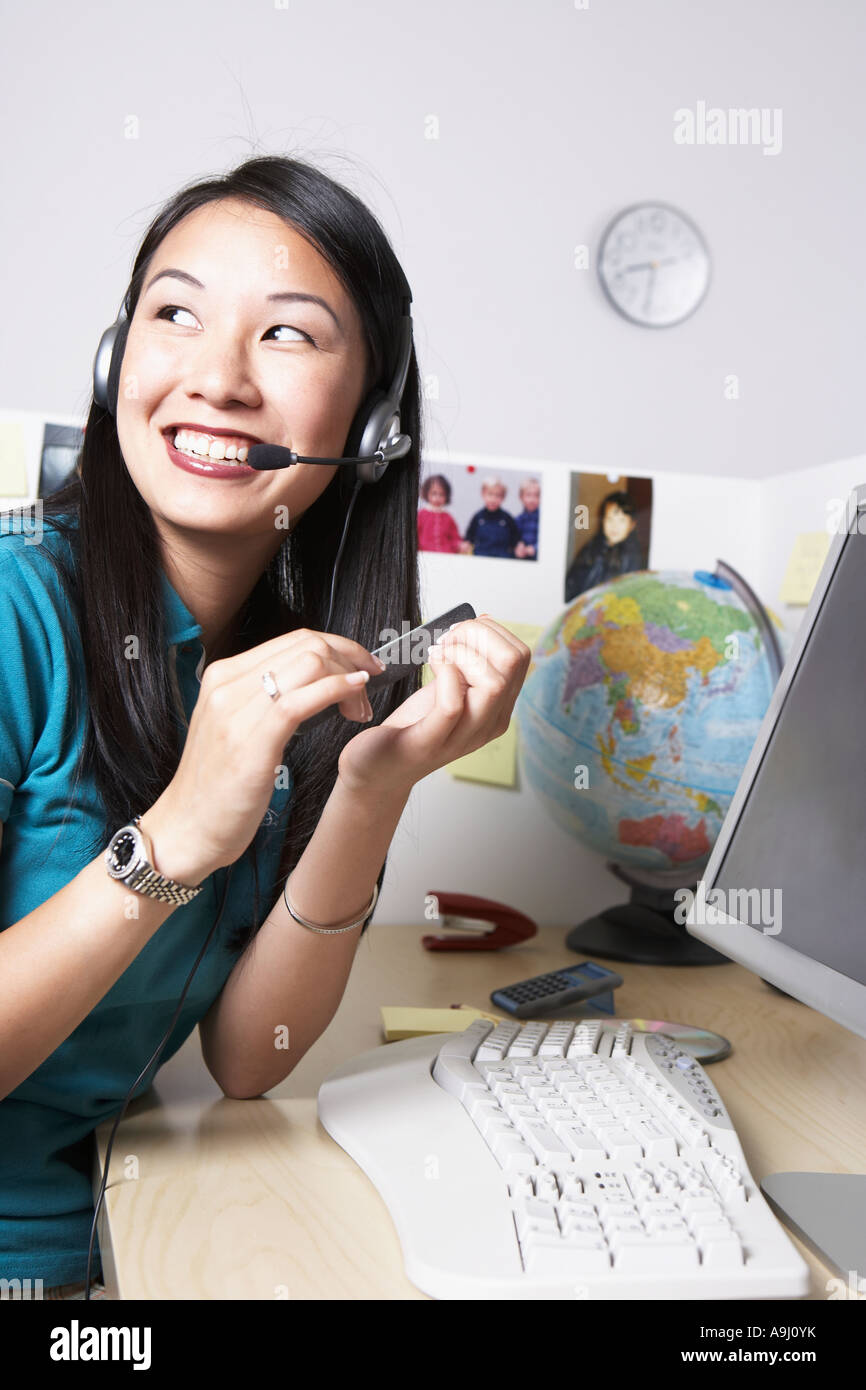 Asian businesswoman filing fingernails at desk Stock Photo - Alamy