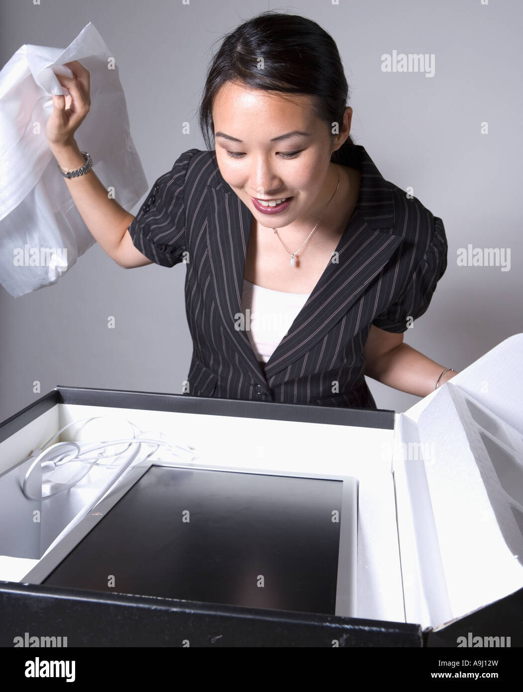 Asian businesswoman opening box with new computer Stock Photo - Alamy
