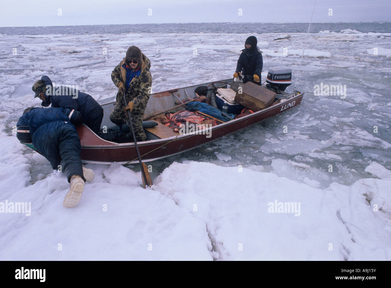 USA Alaska Yupik Eskimos push skiff off sea ice during spring hunting ...