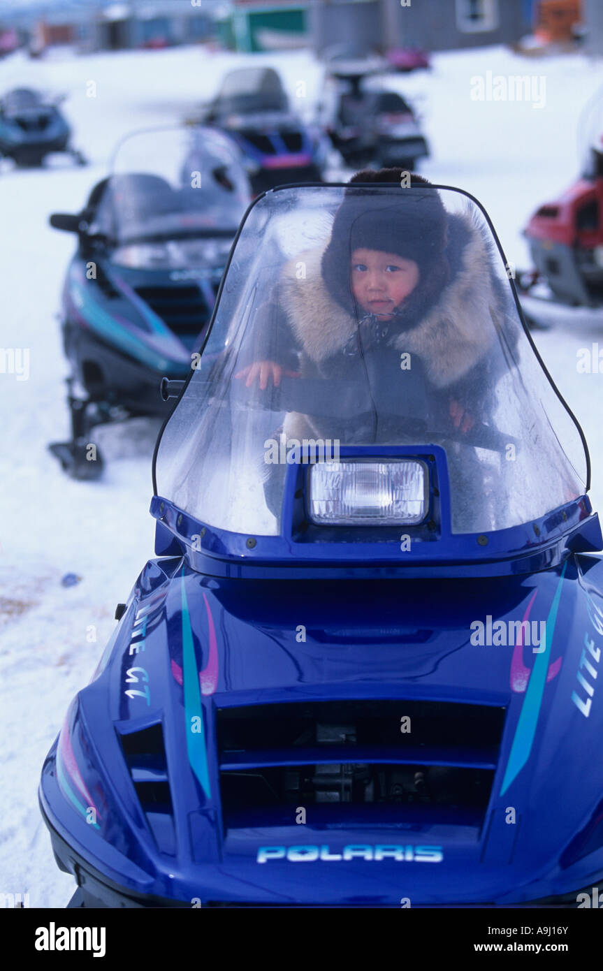 USA Alaska MR Yupik Eskimo boy sits on snowmobile in Bering Sea village ...