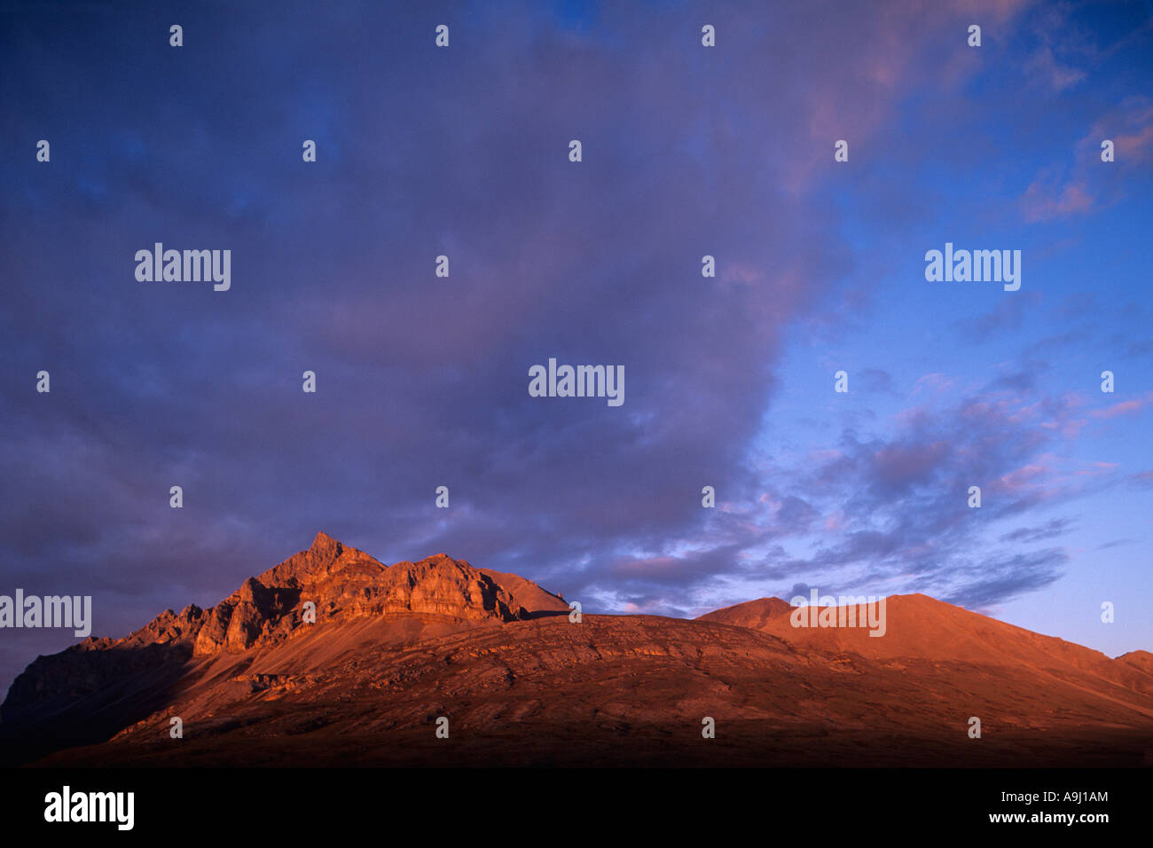 USA Alaska Setting midnight sun lights cliffs above Atigun River Canyon ...