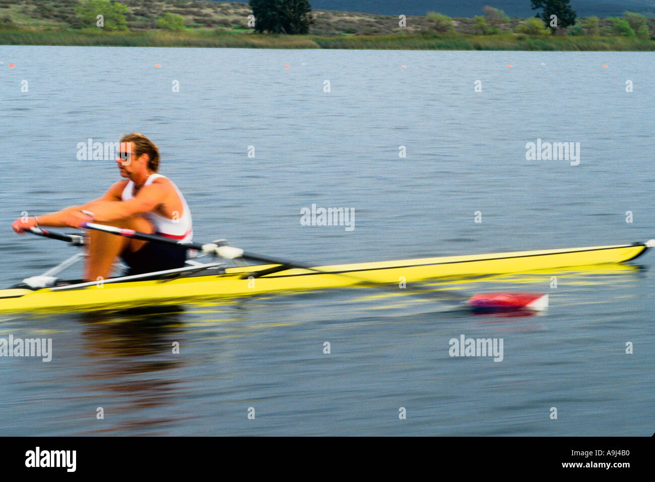 A man rowing a single scull rowboat Stock Photo - Alamy
