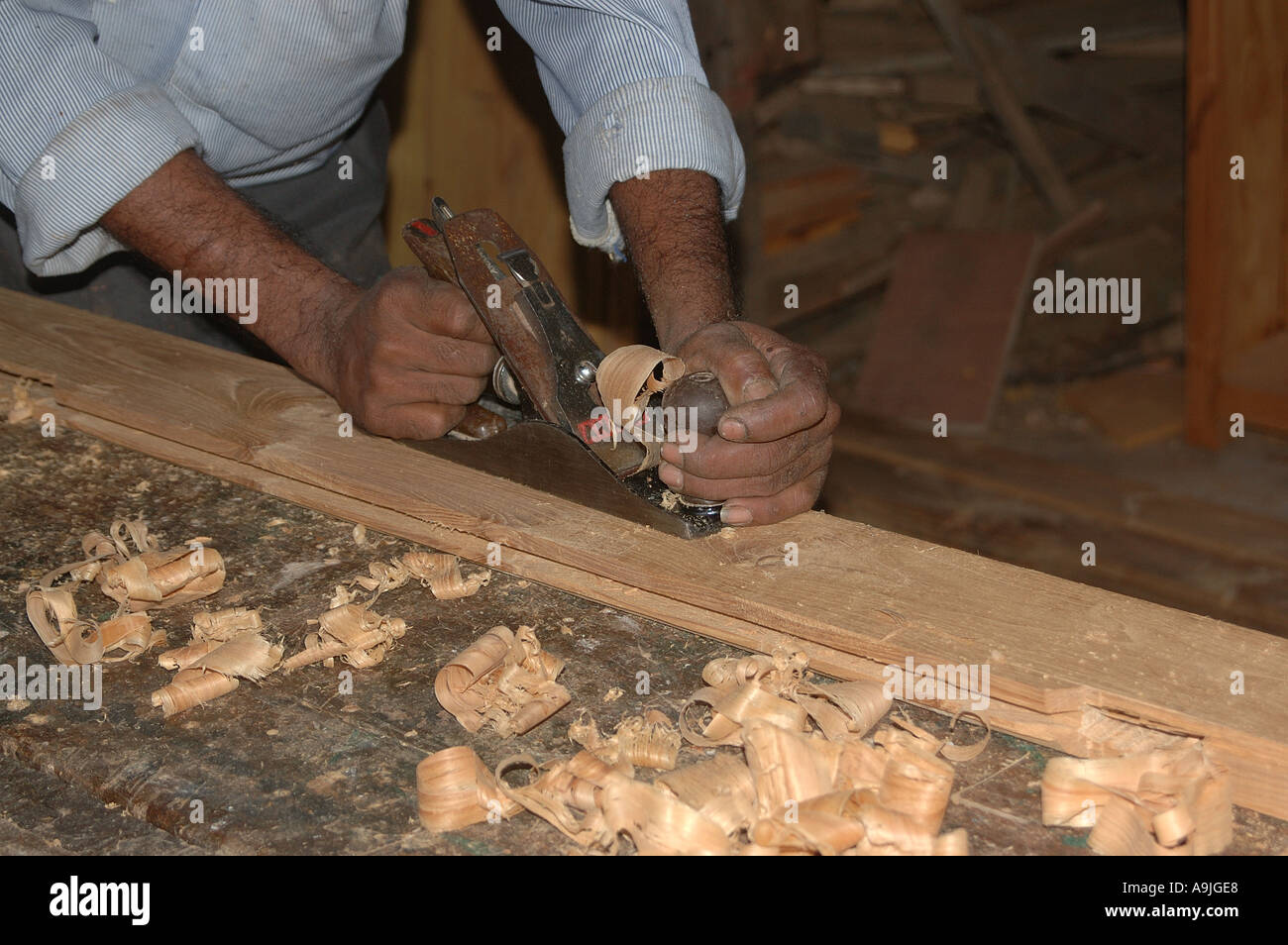 ANG99171 Carpenter smoothing the wood using the equipment Stock Photo ...