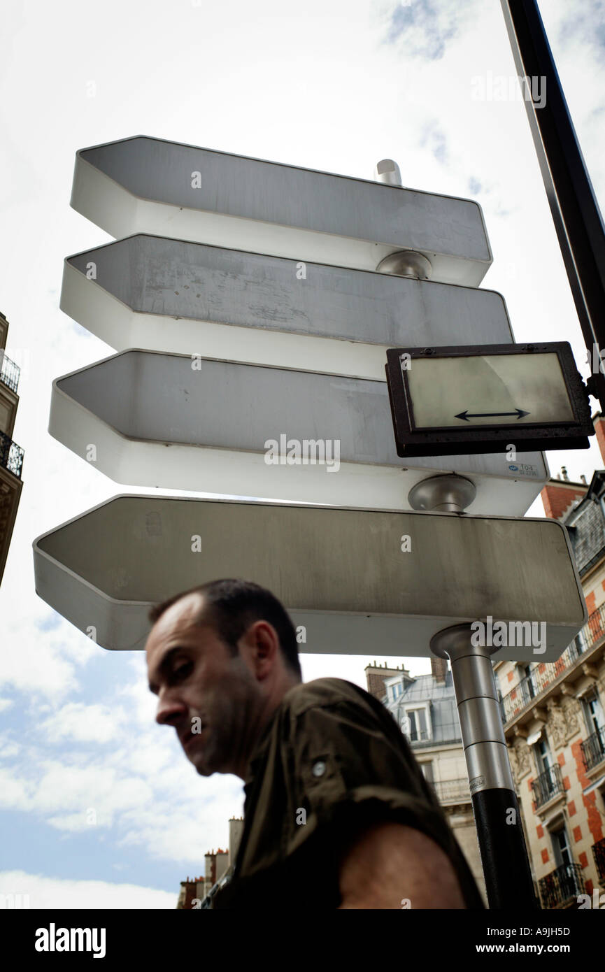 man walking under arrow signs Stock Photo - Alamy
