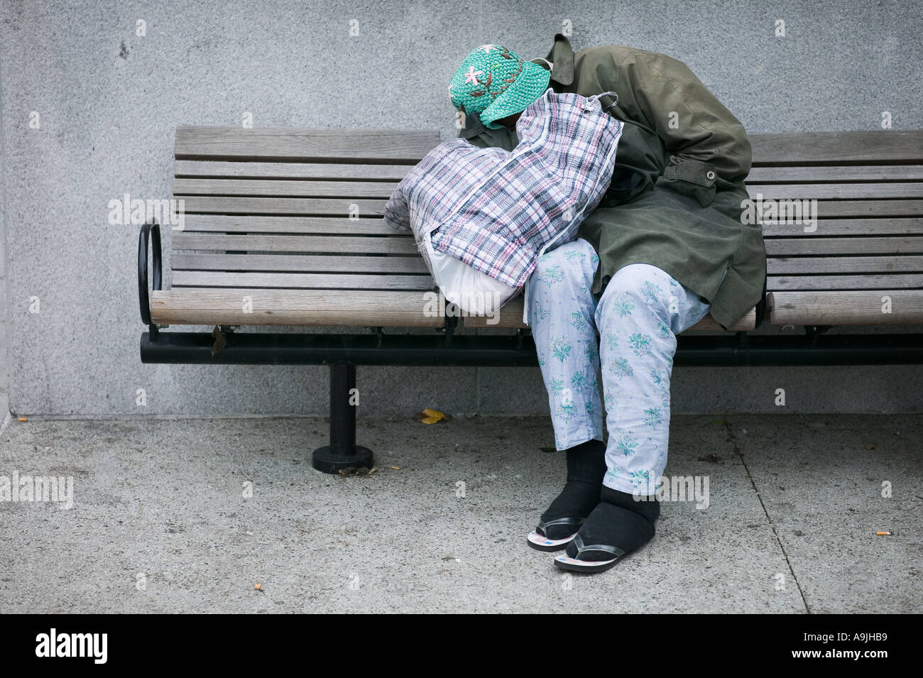 homeless man sitting on a bench Stock Photo - Alamy